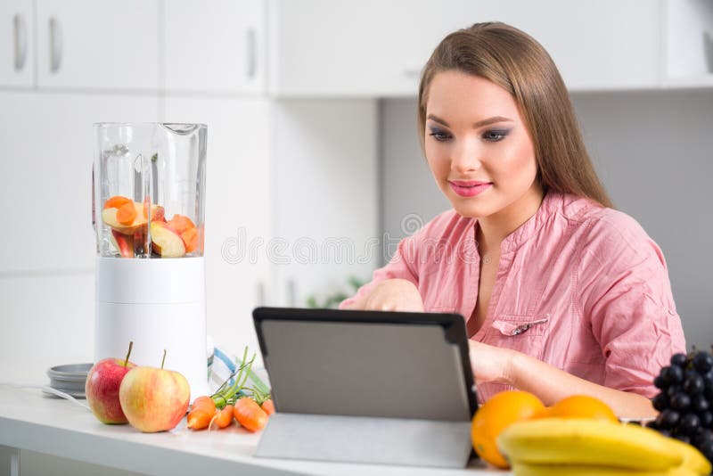 Woman in Kitchen Reading a Recipe from a Digital Tablet Stock Photo ...