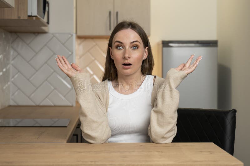 The Woman in the Kitchen is Scared and Folded with an Expression of ...