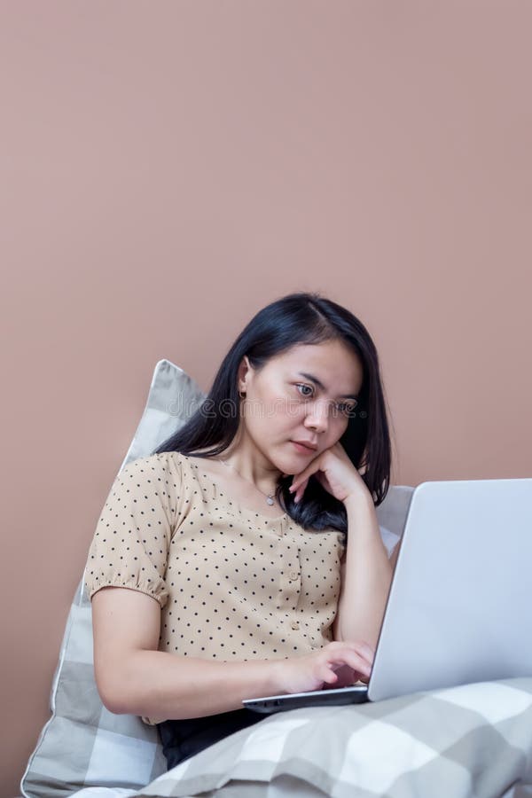 Woman with Laptop on Bed with Flat Face Expression Stock Photo - Image ...