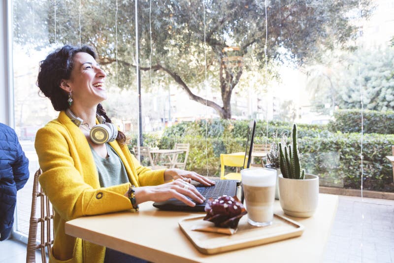 Woman Laughing in Front of a Laptop in a Cafeteria Stock Image - Image ...