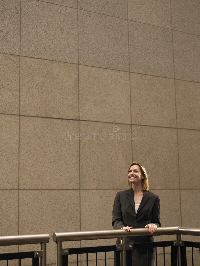 Woman Leaning Against Railing Looking Up Stock Image - Image of ...
