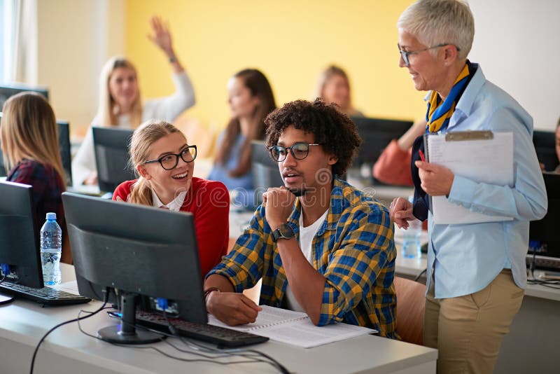 Woman Lecturer in Computer Class Assisting Multi-ethnic Student on ...