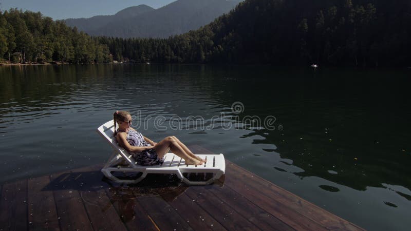 Woman Sit On A Sunbed In Sunglasses And Swimming Suit Girl Rest On A
