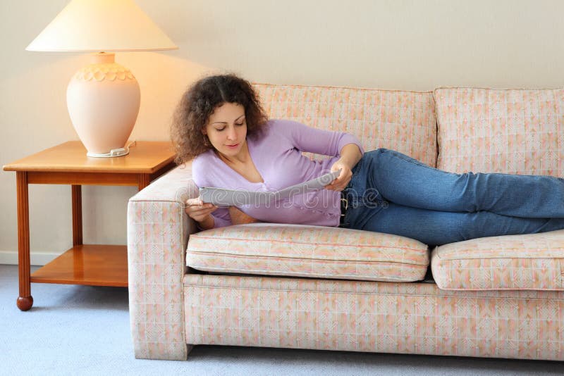 Woman Lies on Couch in Simple Room Stock Image - Image of couch, jeans ...