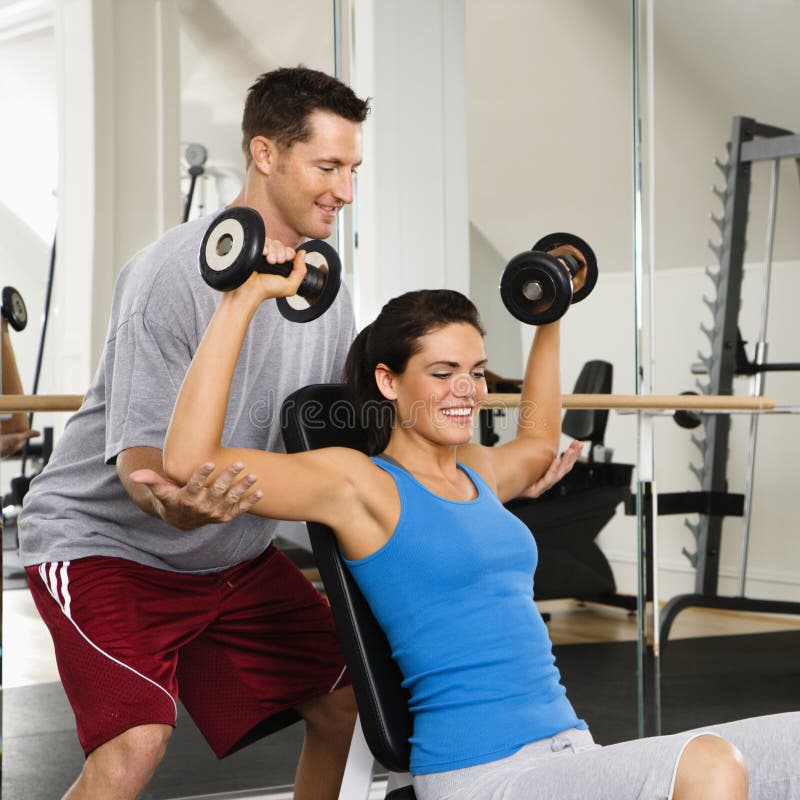 Personal Trainer Helping Woman at Gym Stock Photo - Image of muscles ...