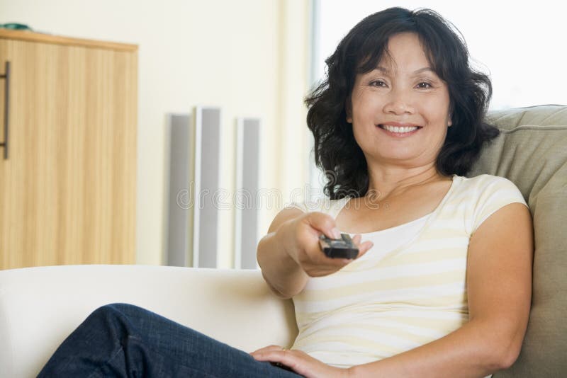 Woman In Living Room Holding Remote Control Stock Photo - Image of ...