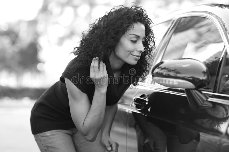 Woman looking into a car stock image. Image of black - 18568341