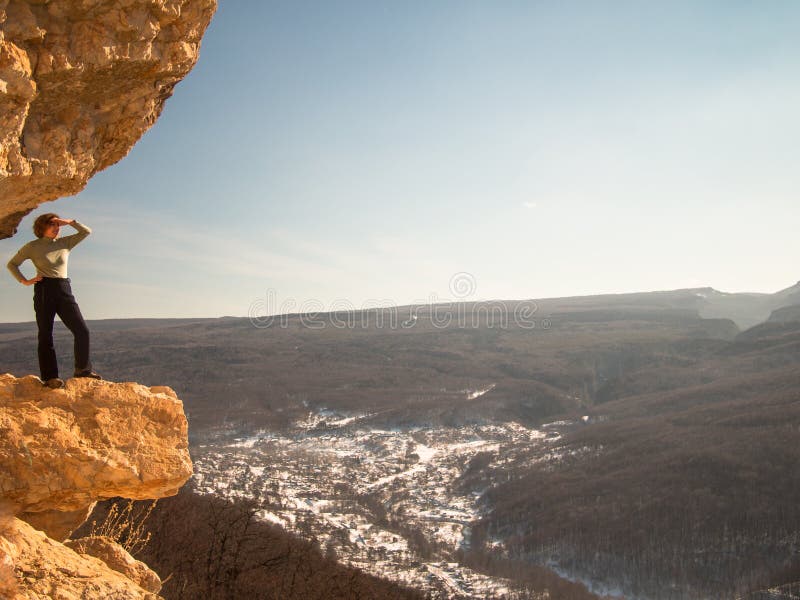 Man Standing on a Ledge of a Mountain, Enjoying the Beautiful Sunset ...