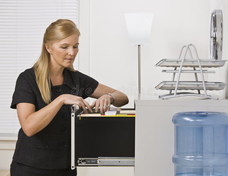 Woman Looking through Filing Cabinet Stock Photo - Image of ...