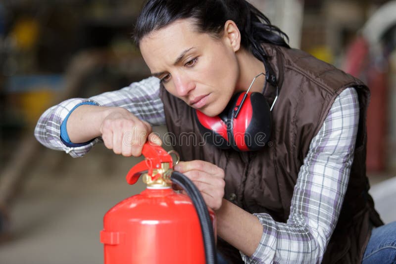 Woman Looking at Fire Extinguisher Stock Image - Image of fire ...
