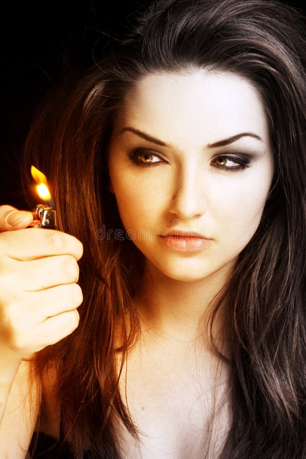Woman looking at a lighter stock photo. Image of beautiful - 15987286
