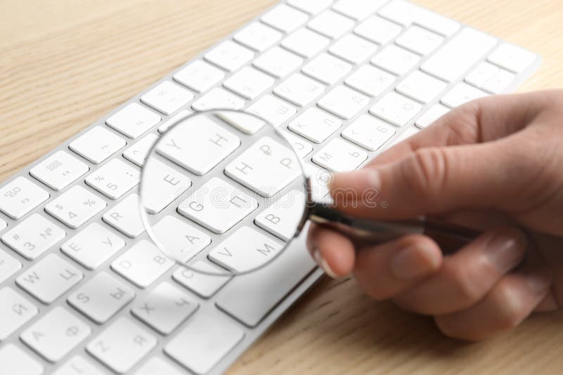 Woman Looking through Magnifying Glass at Computer Keyboard on Table ...