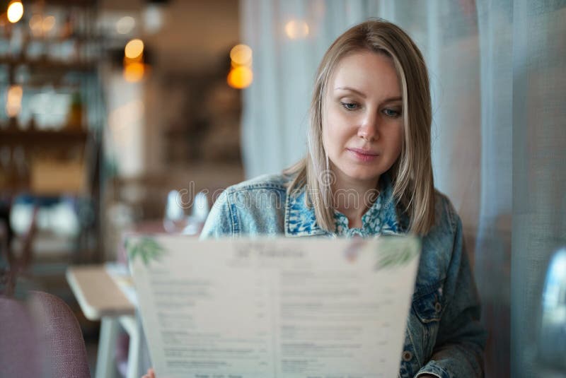 Woman is looking at menu stock image. Image of menu - 229355067