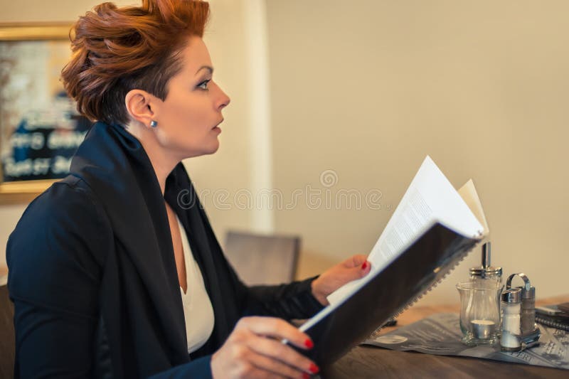 Woman looking at the menu stock photo. Image of indoors - 71385266