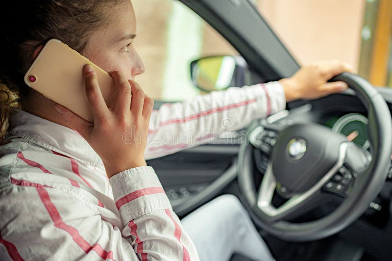 Woman Looking at Mobile Phone while Driving a Car. Driver Using Smart ...