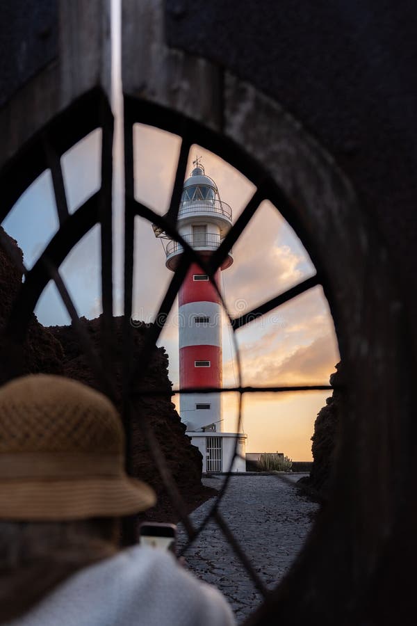 A Woman is Looking Out of a Window at a Lighthouse Stock Photo - Image ...