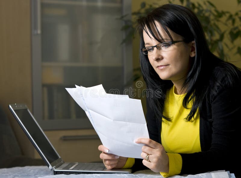 Woman Looking Over Paperwork Stock Image - Image of caucasian, works ...