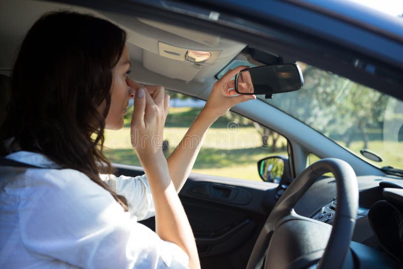 Pretty Young Woman Looking In Mirror While Driving Car In The Road ...