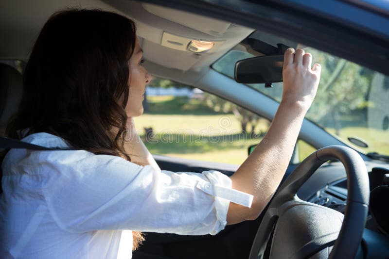 Woman Looking into Rear View Mirror while Driving a Car Stock Image ...