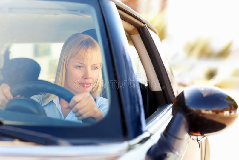 Woman Looking at Side View Mirror while Driving a Car. Blond Woman ...