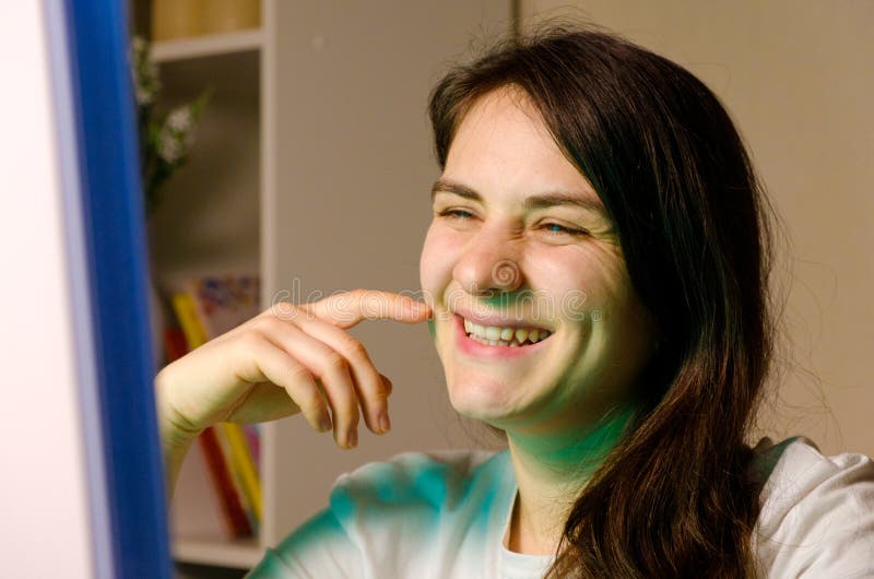 The Woman Looks at the Computer Screen and Smiles. Stock Photo - Image ...