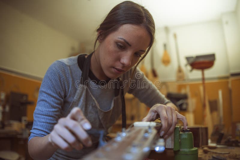 A Woman Luthier is Tuning a Classic Guitar in Her Musical Instrument ...
