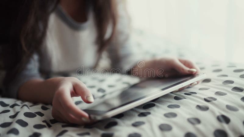 Woman Lying in Bed with Digital Tablet Touching with Finger. View from ...