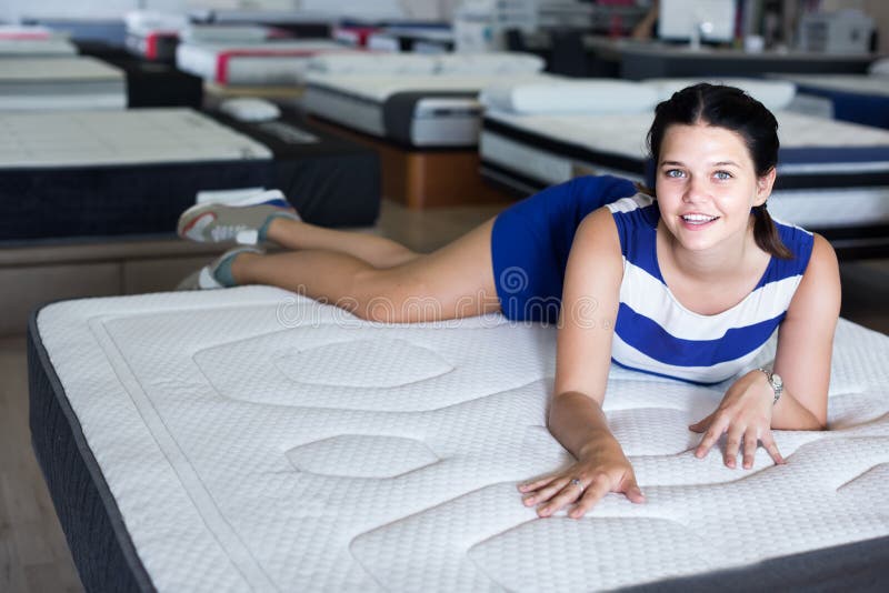 Woman is Lying on Bed and Testing Mattress in the Store. Stock Image ...