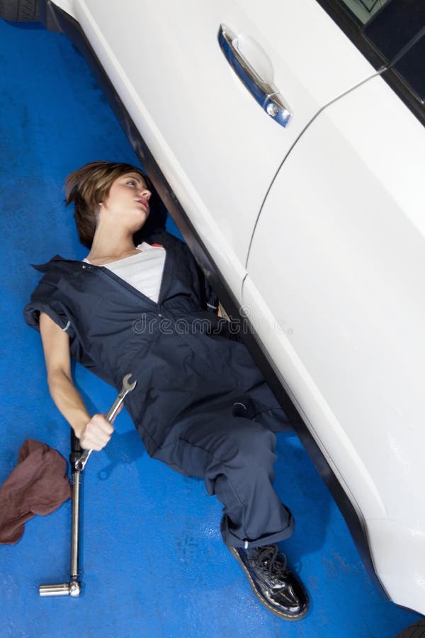 Woman Lying Down on Floor Working on Car in Automobile Garage Stock ...