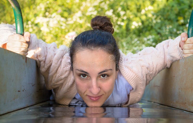 Woman Lying on Front Side, on a Park Slide. Stock Photo - Image of ...