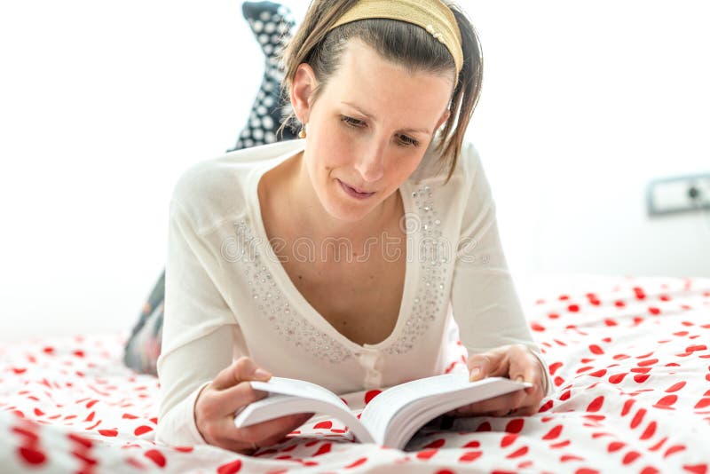 Woman Lying On Her Stomach While Reading A Book Stock Image Image Of
