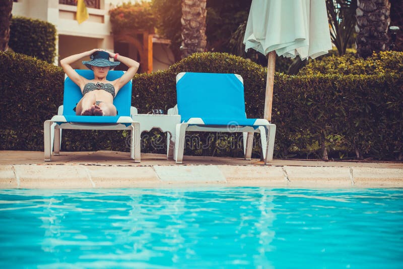 Woman Lying on a Lounger by the Pool Stock Photo - Image of people ...