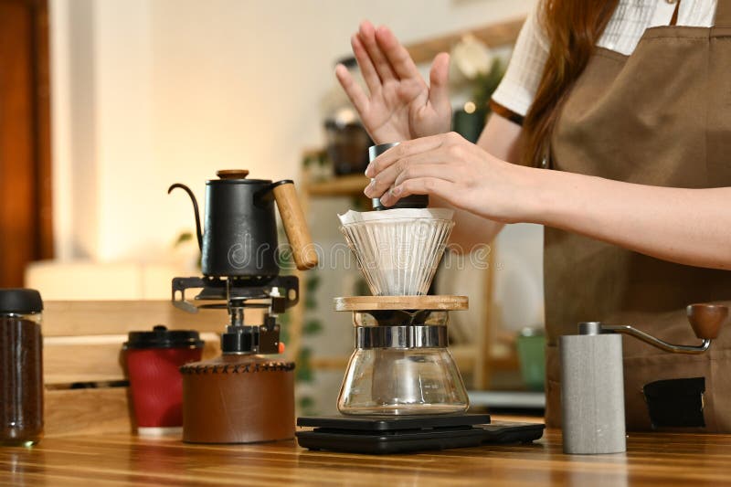 A Woman is Making Coffee Using a French Press. she is Pouring Coffee ...
