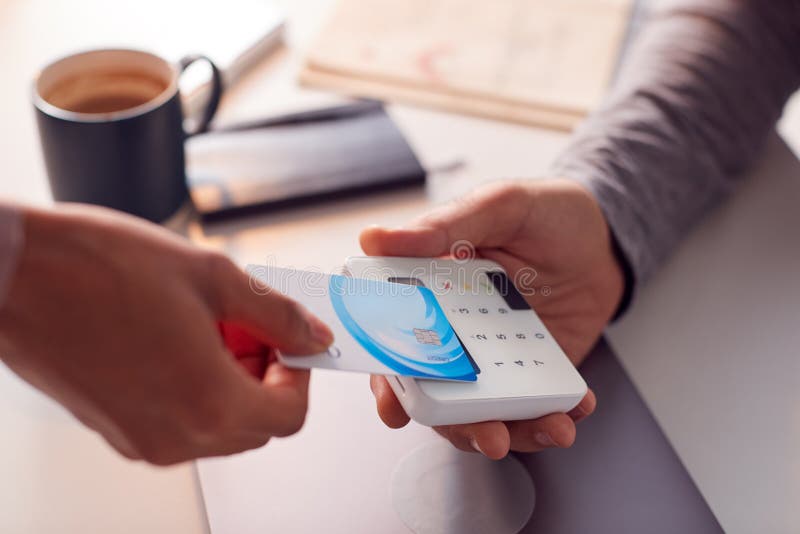 Woman Making Contactless Payment Using Credit Card To Man Holding Card ...