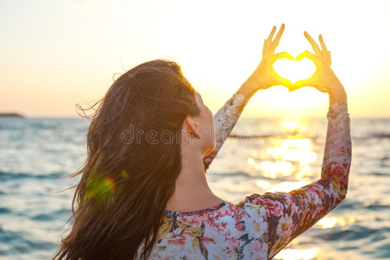 Woman Making Heart with Her Hands Round the Sun in Sunset Stock Photo ...