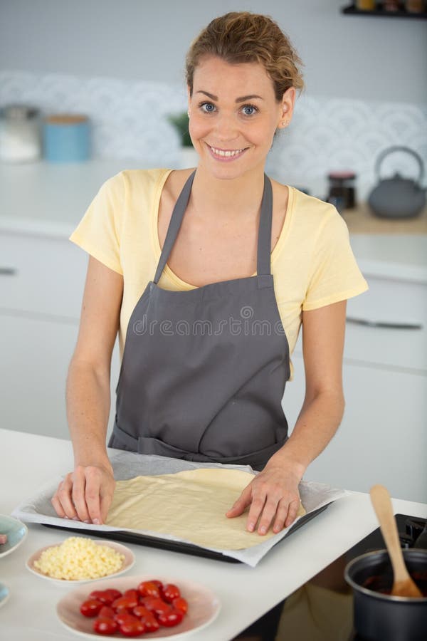 Woman making pizza at home stock photo. Image of preparation - 317246610