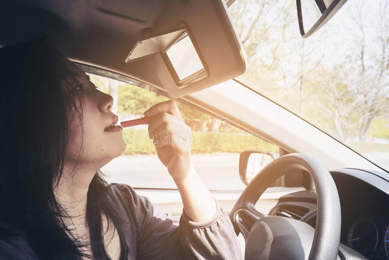 Woman Making Up Her Face Using Lipstick while Driving Car Stock Image ...