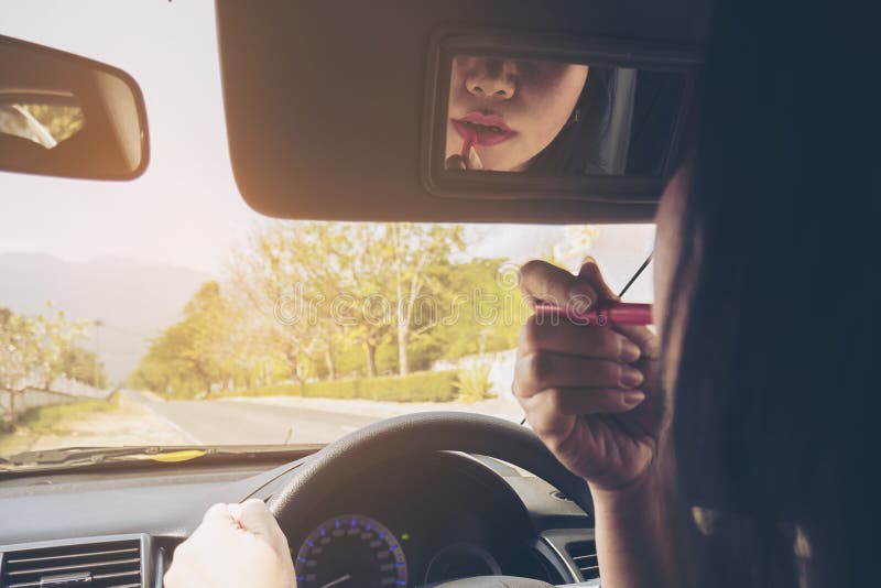 Woman Making Up Her Face Using Lipstick while Driving Car Stock Photo ...