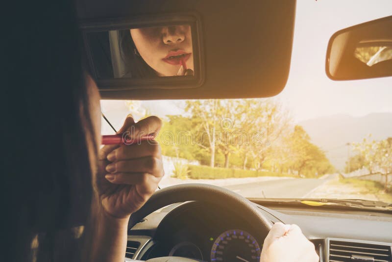 Woman Making Up Her Face Using Lipstick while Driving Car Stock Image ...