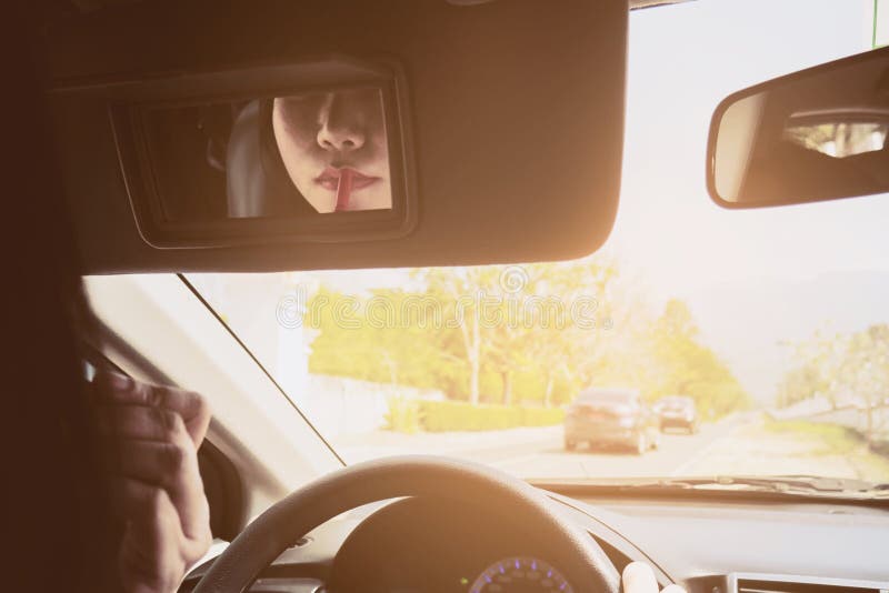 Woman Making Up Her Face Using Lipstick while Driving Car Stock Image ...
