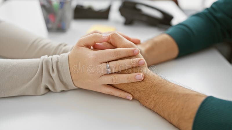 A Woman and a Man Hold Hands on a Table in an Office, Showcasing ...