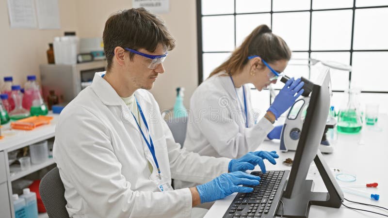 A Woman and Man in a Laboratory Working on Research with a Microscope ...