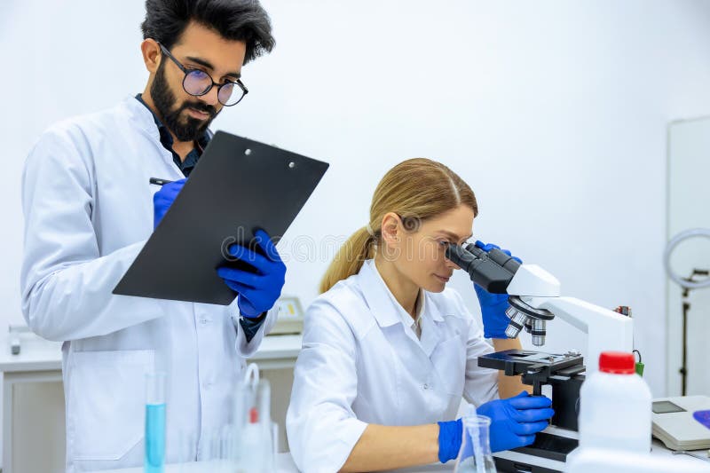 Woman and Man Scientists in Lab Coat Making Notes after Doing Sample ...