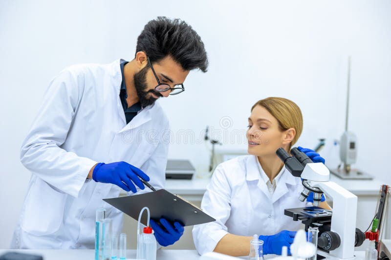 Woman and Man Scientists in Lab Coat Making Notes after Doing Sample ...