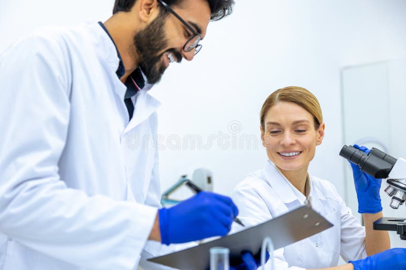Woman and Man Scientists in Lab Coat Making Notes after Doing Sample ...