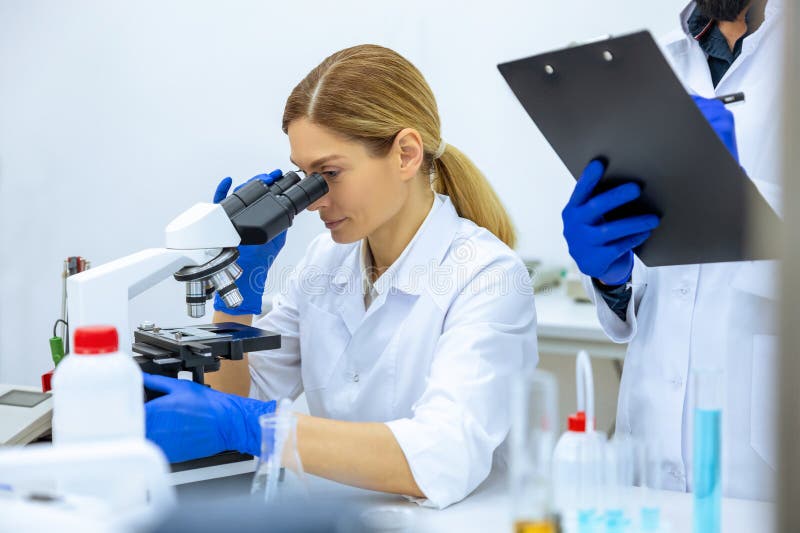 Woman and Man Scientists in Lab Coat Making Notes after Doing Sample ...