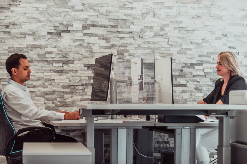 A Woman and a Man are Sitting in a Modern Office and Working on a ...