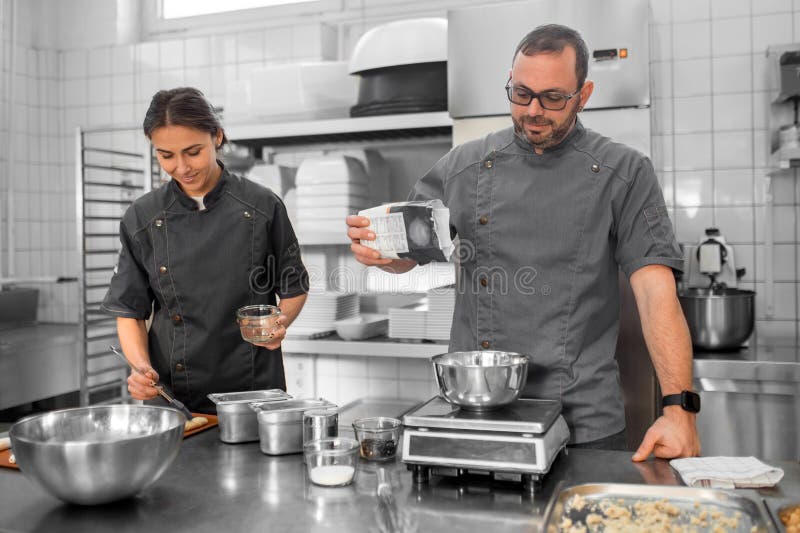 Woman and Man in Uniform Kneading Dough in Kitchen Preparing Pastry in ...