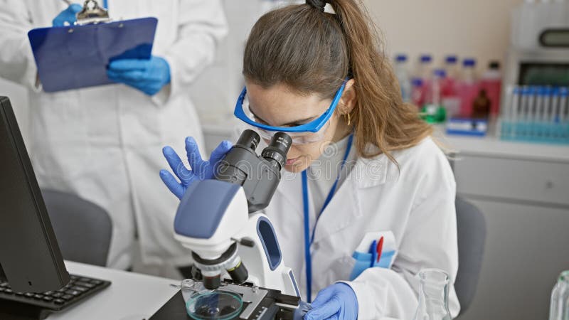 A Woman and Man Work Together in a Laboratory, with Her Using a ...