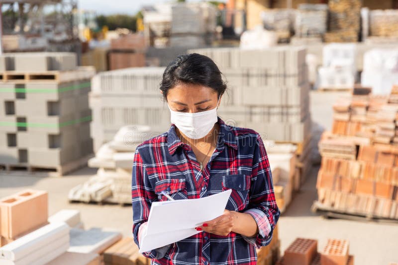 Woman Manager in Protective Mask Keeps Records of Building Materials in ...
